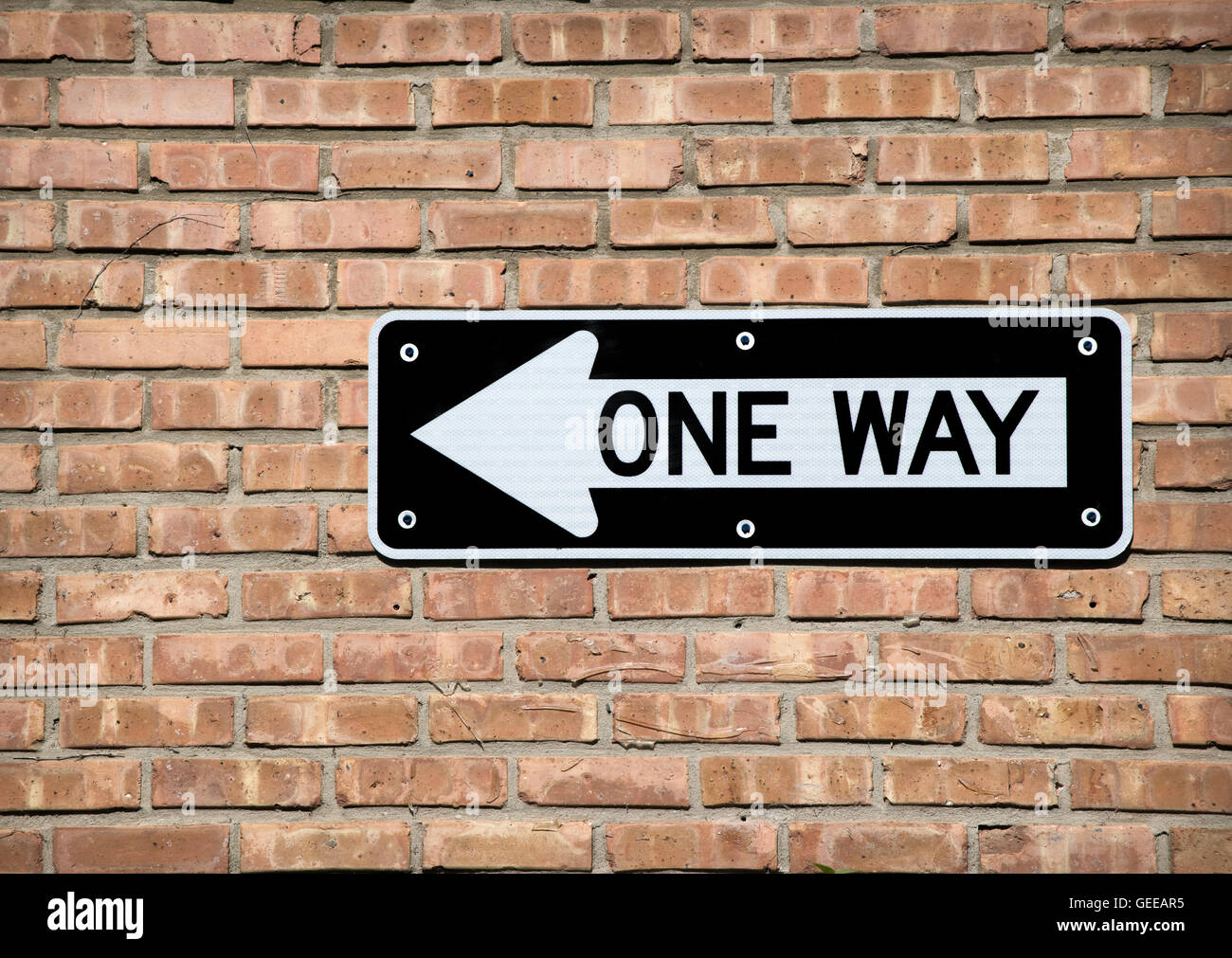 One way sign against a brick wall Stock Photo - Alamy