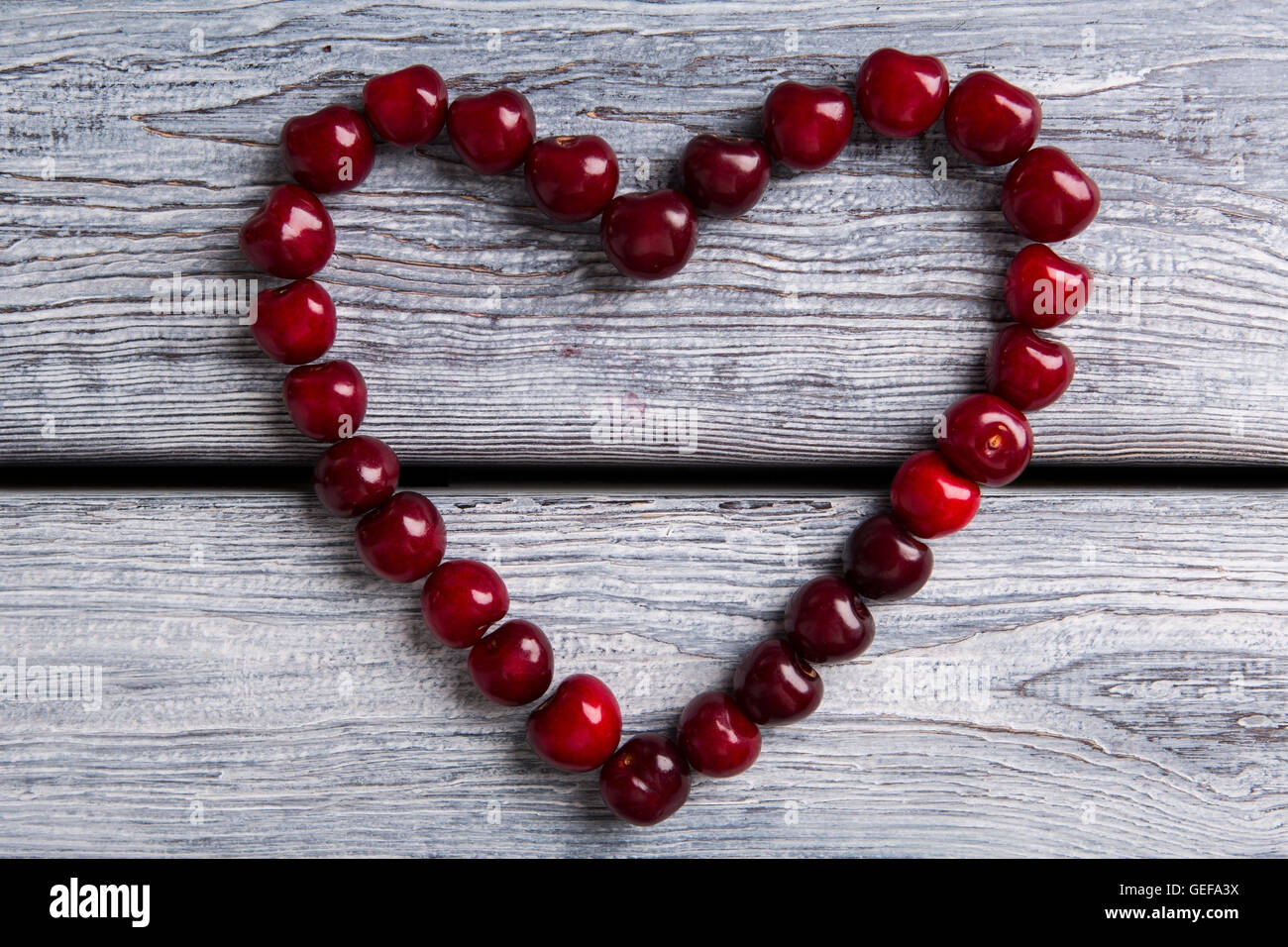 Heart made of cherries. Fruit on gray wooden background. Keep your ...