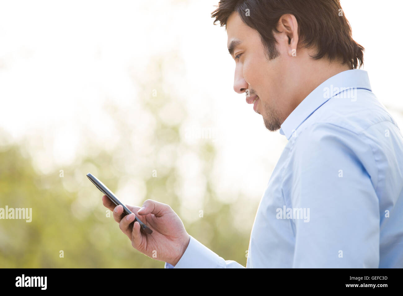 Young Chinese man using a smart phone Stock Photo - Alamy