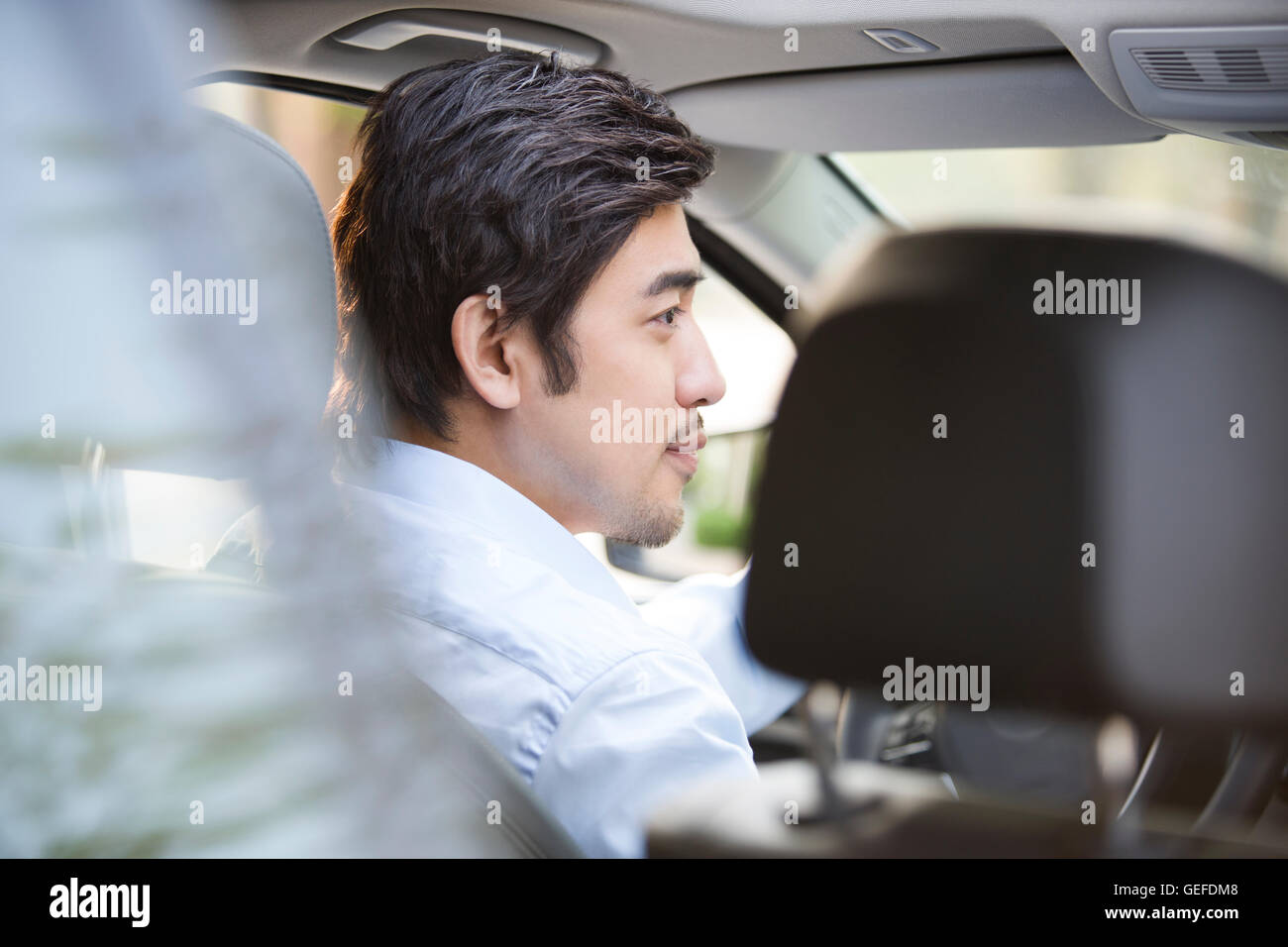 Young Chinese man driving car Stock Photo - Alamy