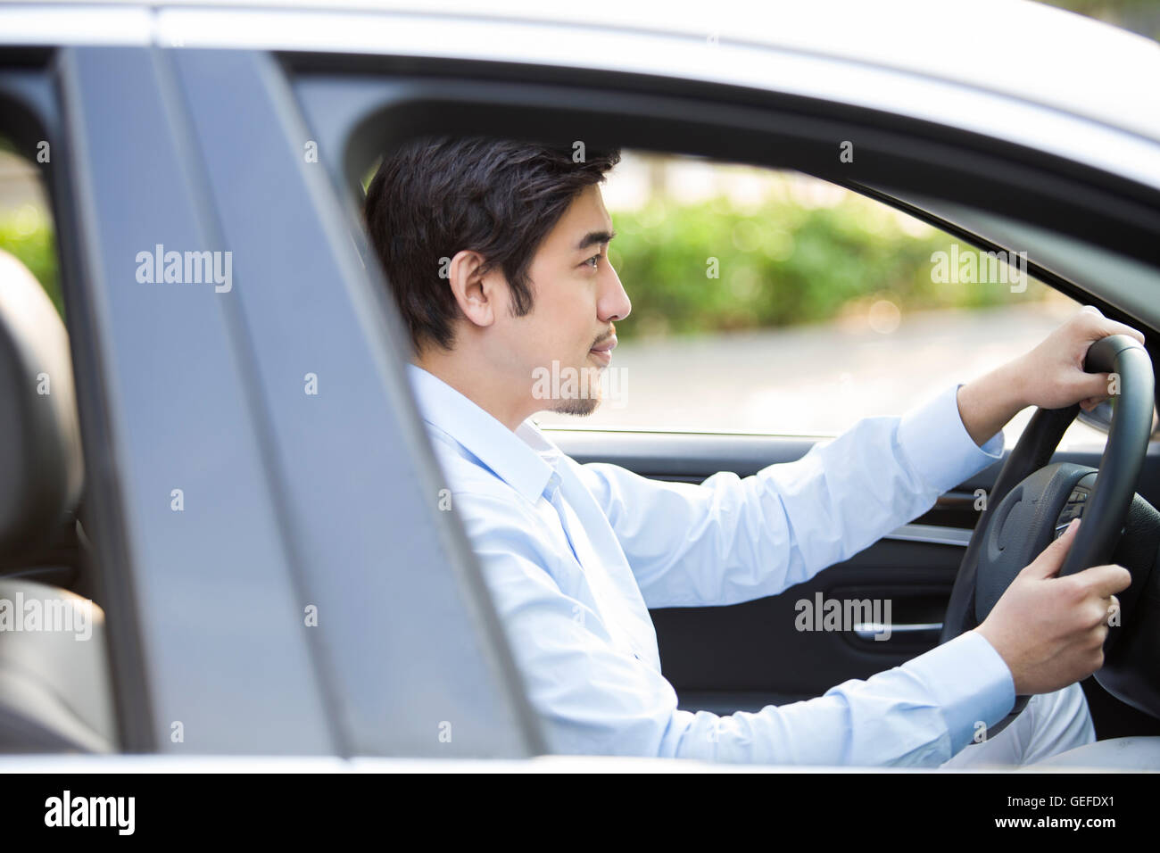 Young Chinese man driving car Stock Photo - Alamy