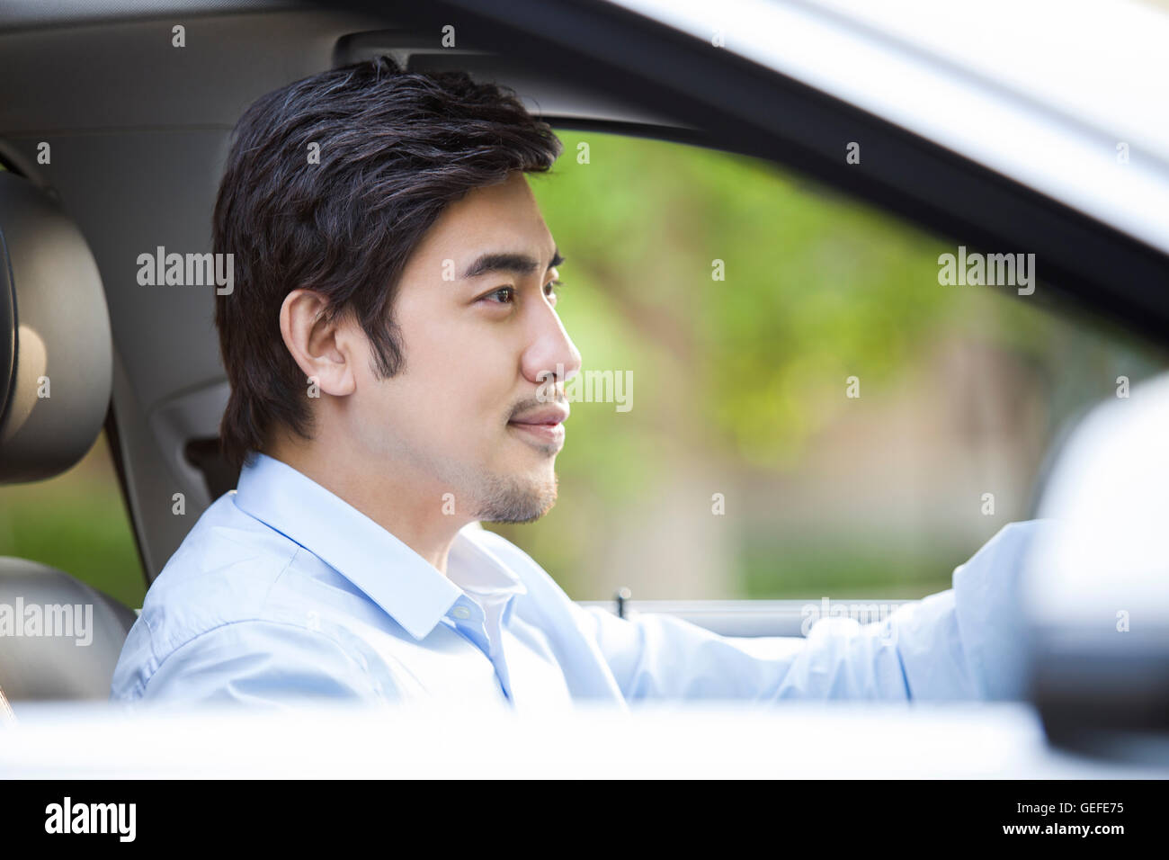 Young Chinese man driving car Stock Photo - Alamy