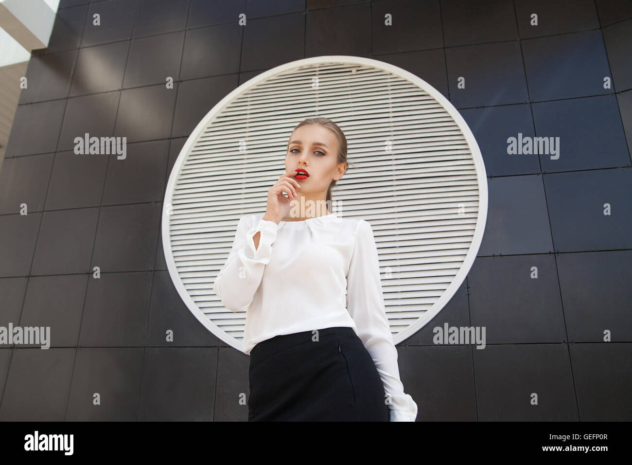 Model looking away against of building wall Stock Photo - Alamy