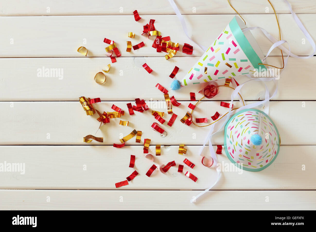 Party hat next to colorful confetti on wooden table. Top view Stock ...