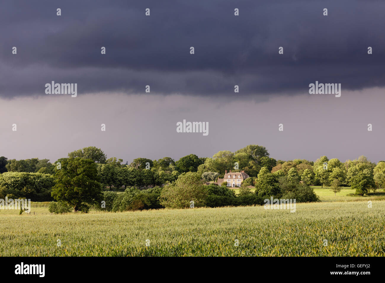Farmhouse and farm in storm light Stock Photo - Alamy