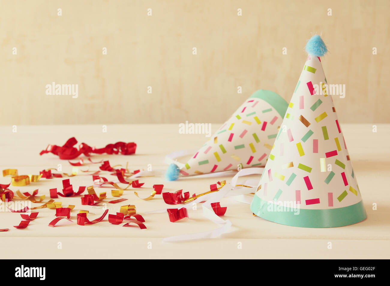 Party hat next to colorful confetti on wooden table. Top view Stock ...