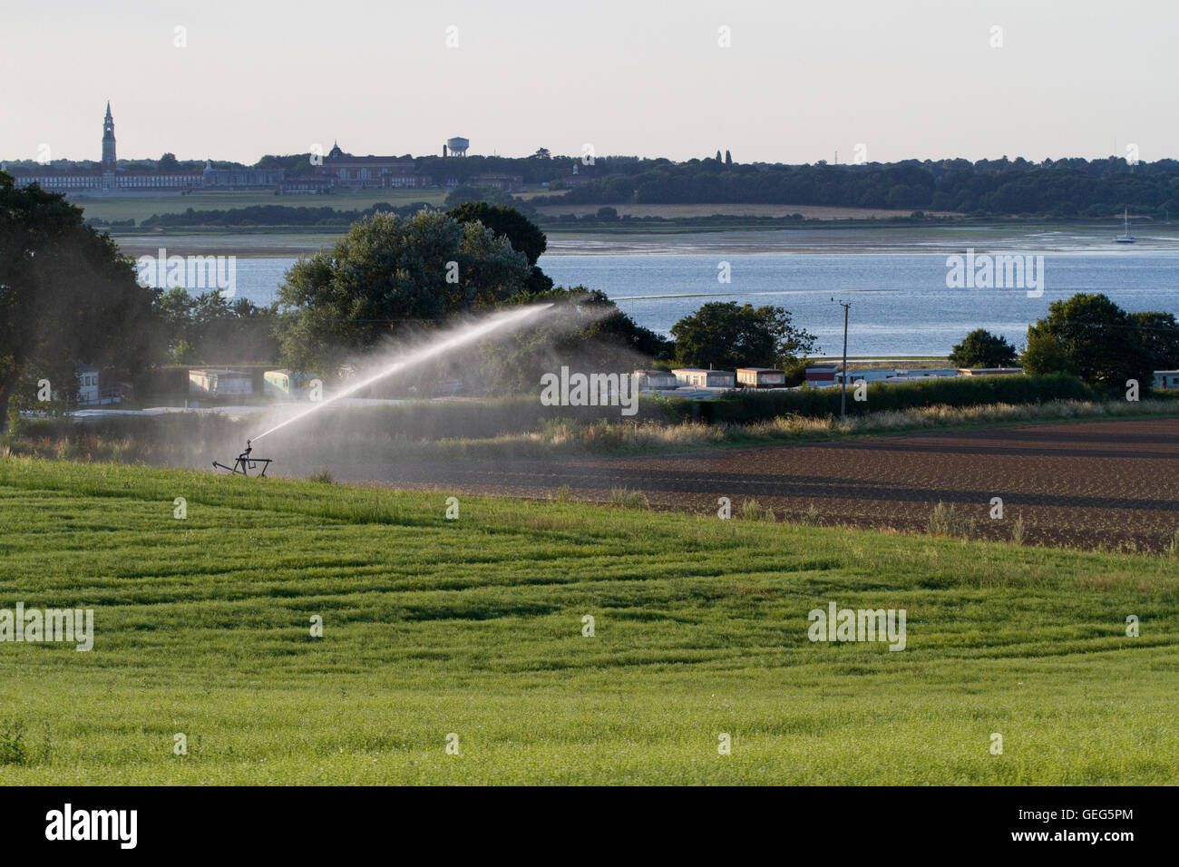 A field being irrigated by the River Stour and a caravan park with the ...