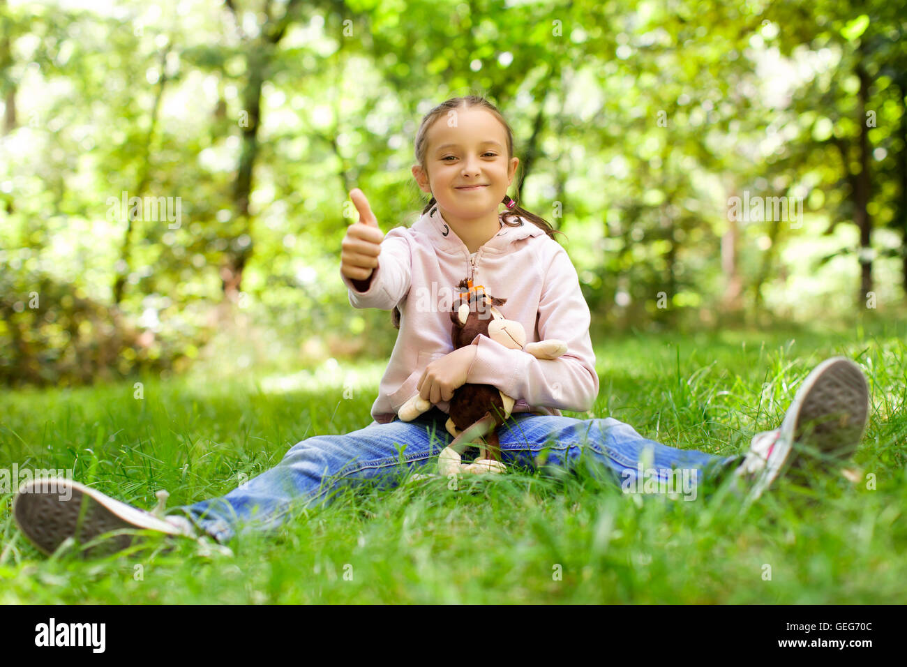 Girl sitting on grass laughing hi-res stock photography and images - Alamy