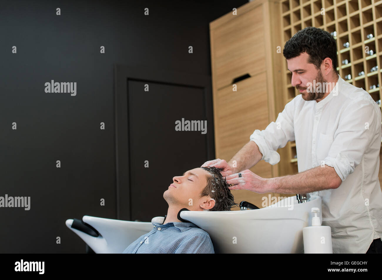 Young man at hairdresser salon getting his hair washed Stock Photo - Alamy