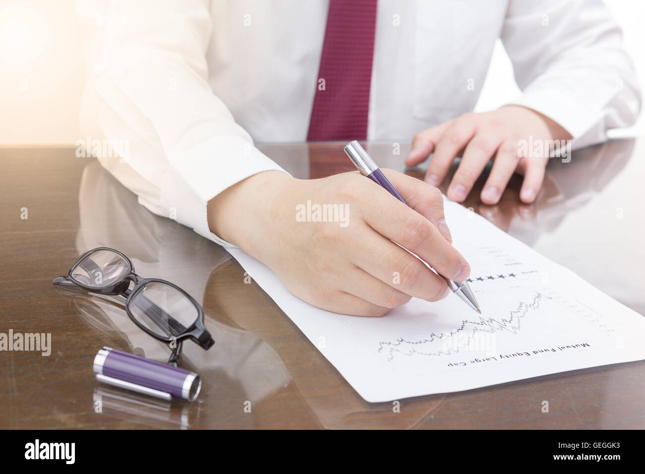 Businessman pointing his pen at mutual fund return and benchmark line ...