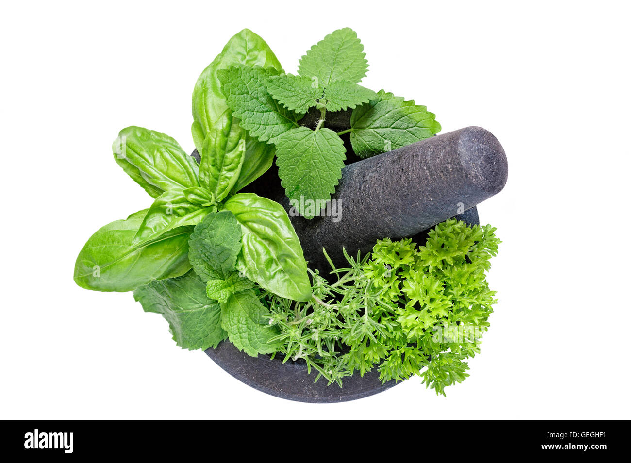 Top view of a massive gray granite mortar and pestle with herbs inside ...