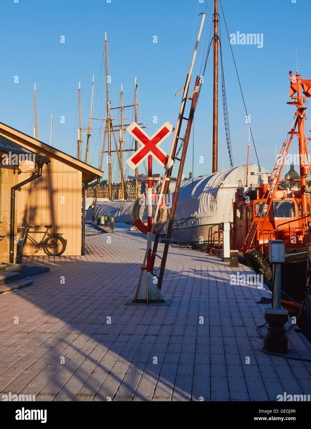 Red X warning sign on icy boardwalk and boats moored, Skeppsholmen ...