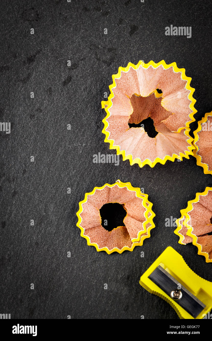 Yellow shavings pencil and yellow pencil sharpener on black background ...