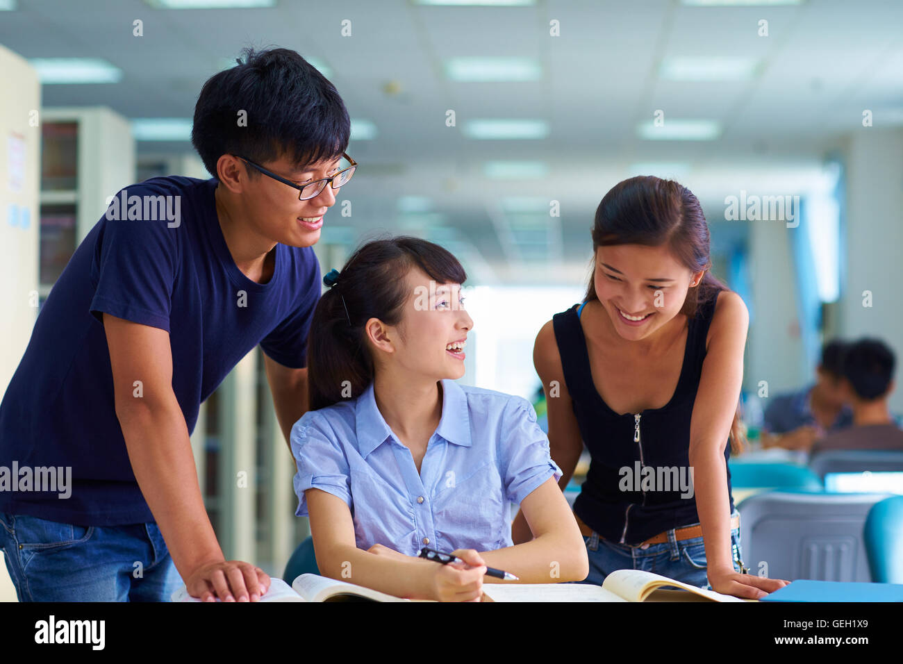 Happy young Chinese or Asian college students study together in the ...