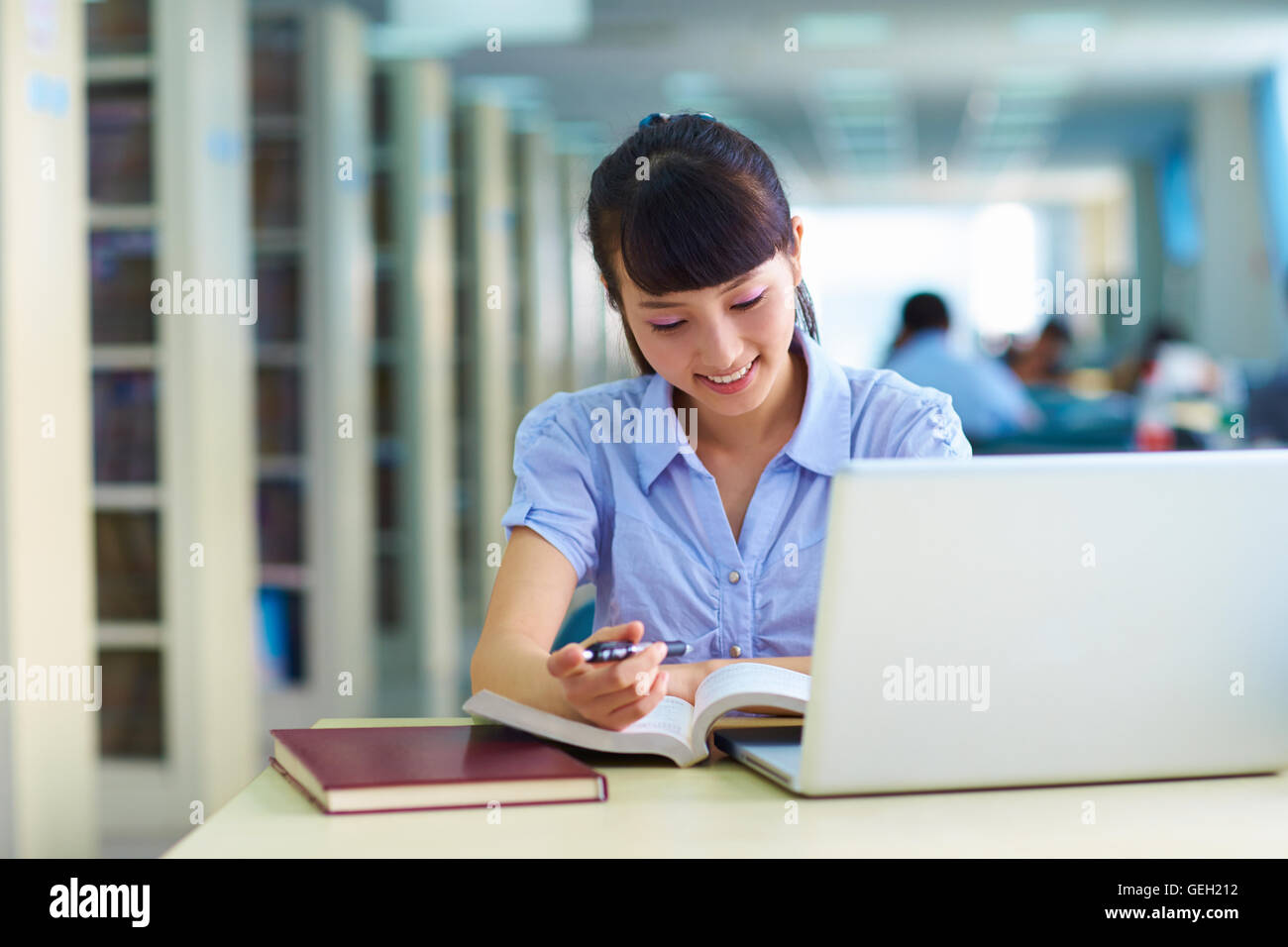 one pretty young Asian or Chinese college student study in the library ...