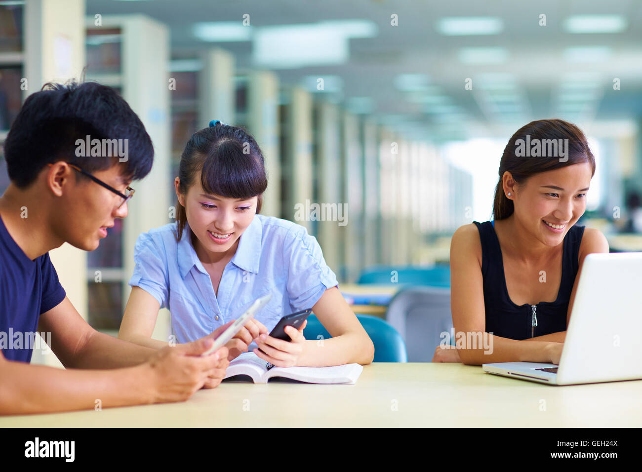 young asian college student using laptop or tablet together in the ...