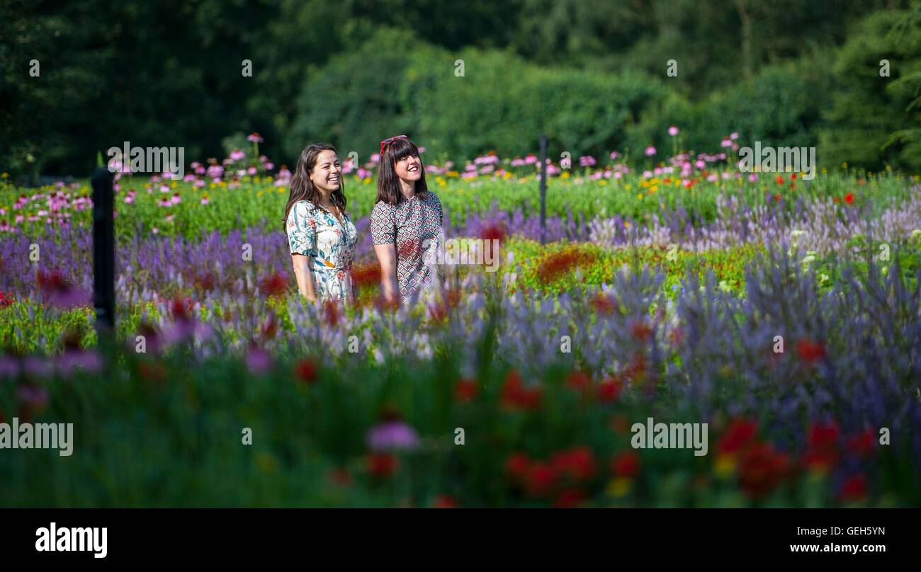Staff walk through part of the Great Broad Walk Borders at Kew Gardens ...