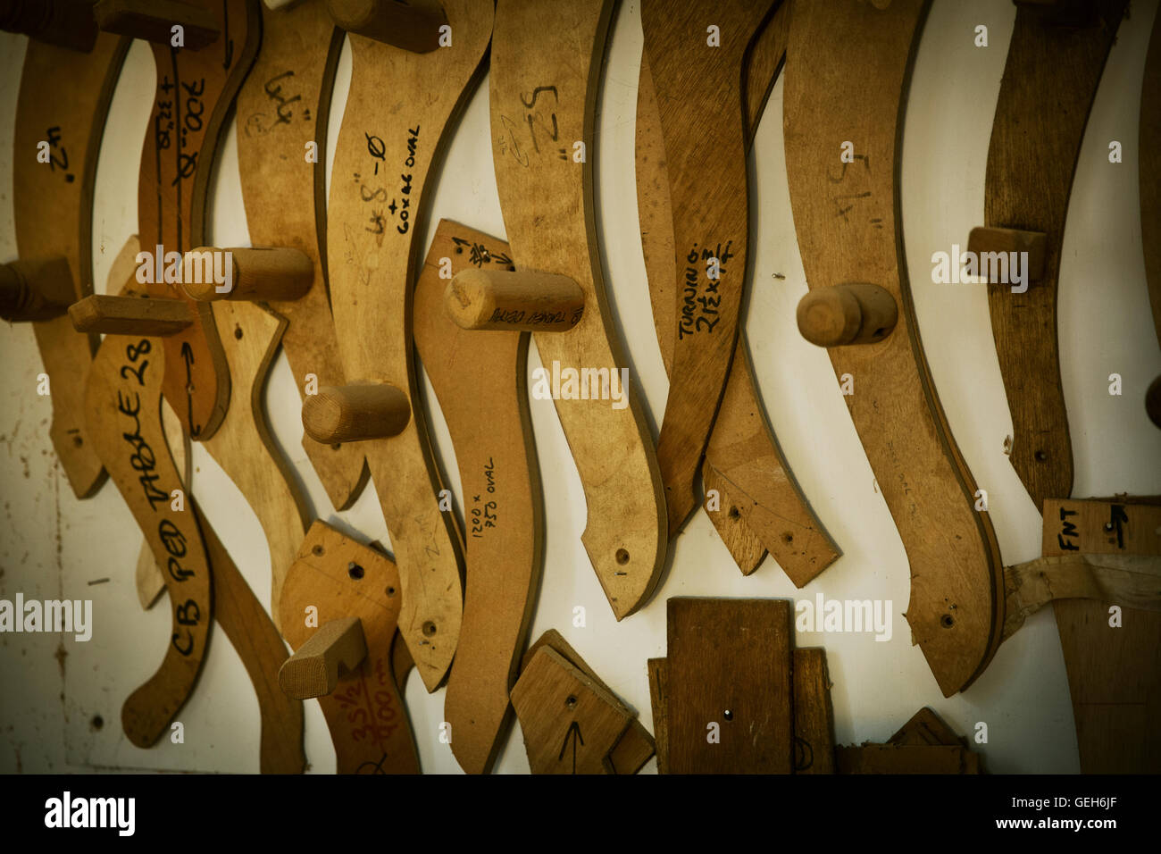 A furniture workshop, wooden chair arm rest templates hanging on the ...