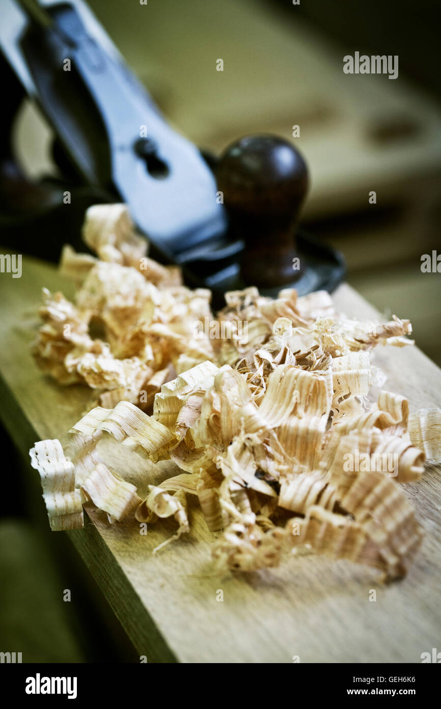 A wood plane on a piece of wood and wood shavings Stock Photo - Alamy