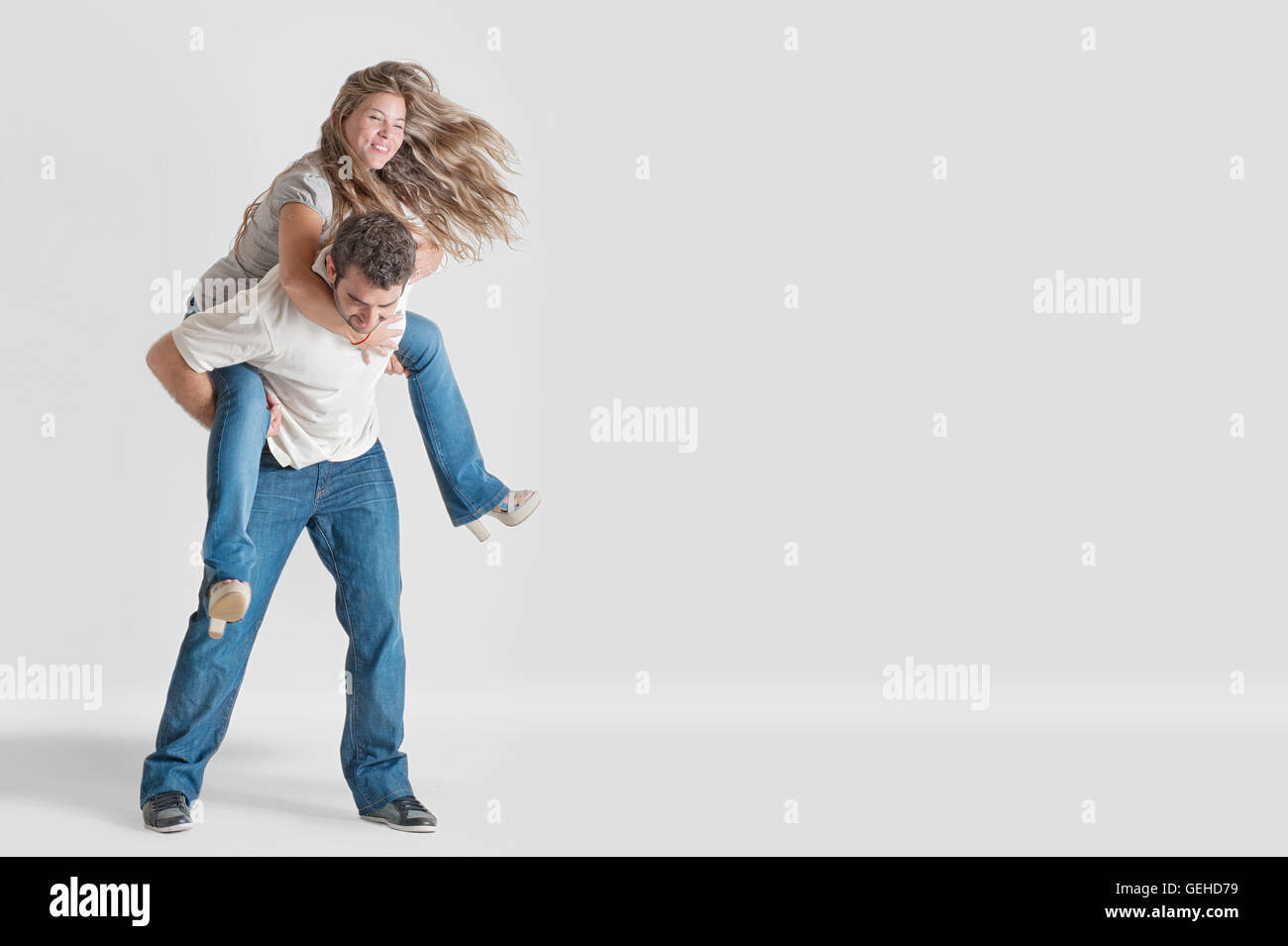 Girl gets a piggyback from her boyfriend Stock Photo - Alamy