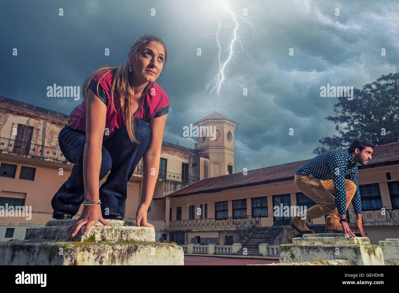 Man and a woman in a ready position to start running with lightning ...