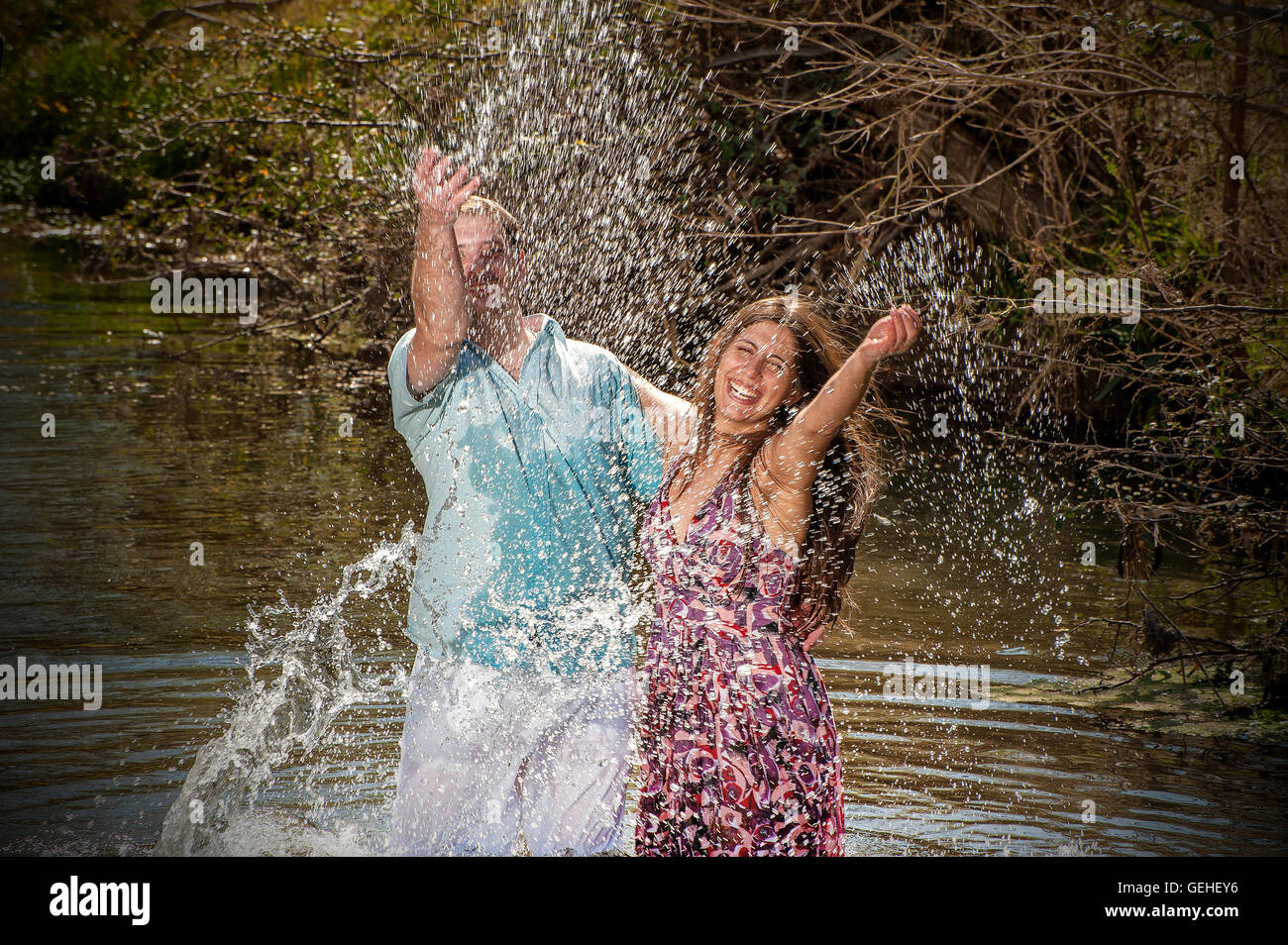 Couple playing in the water splashing each other Stock Photo - Alamy
