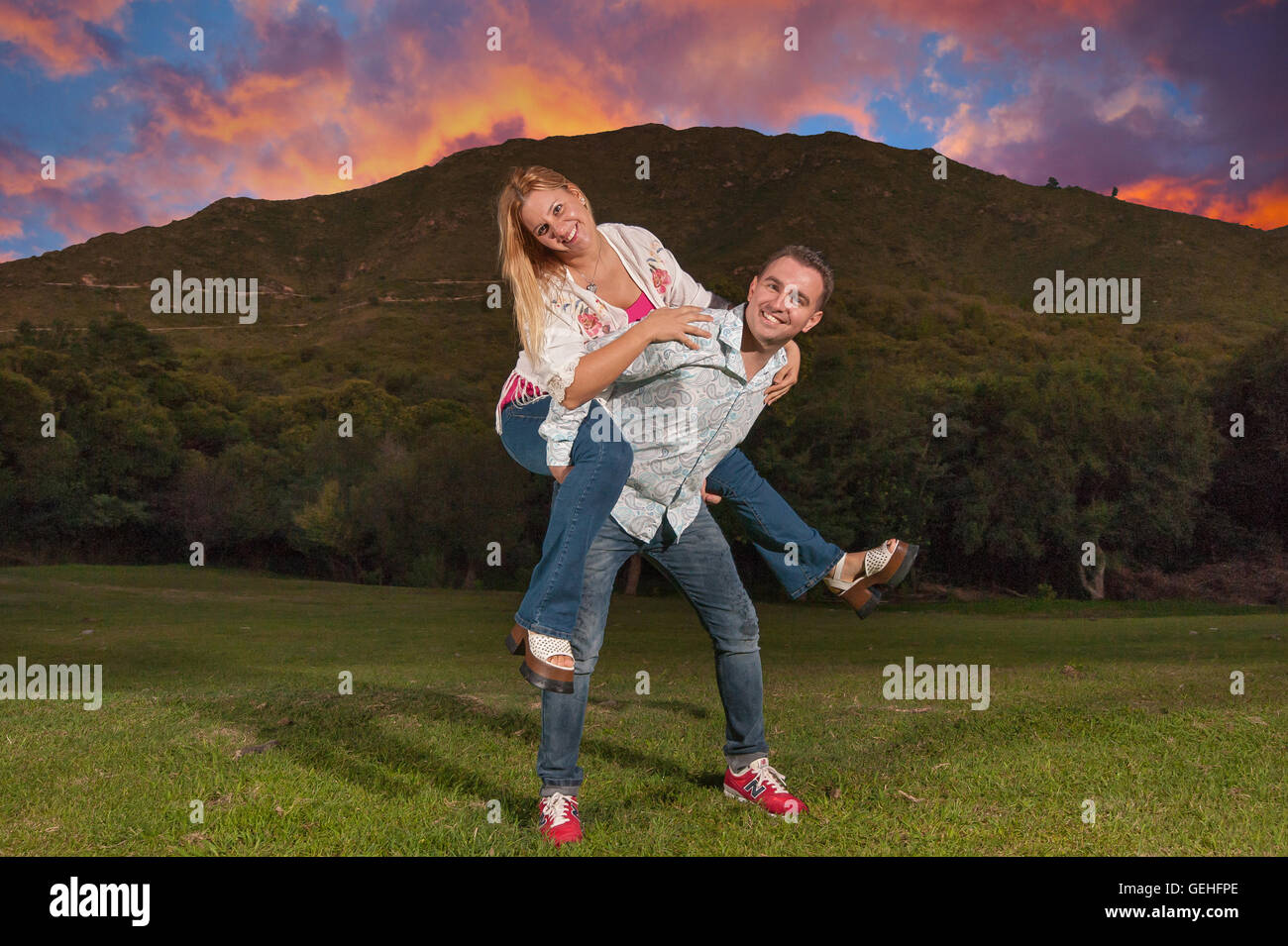 Girl gets a piggyback ride from her boyfriend at sunset Stock Photo - Alamy