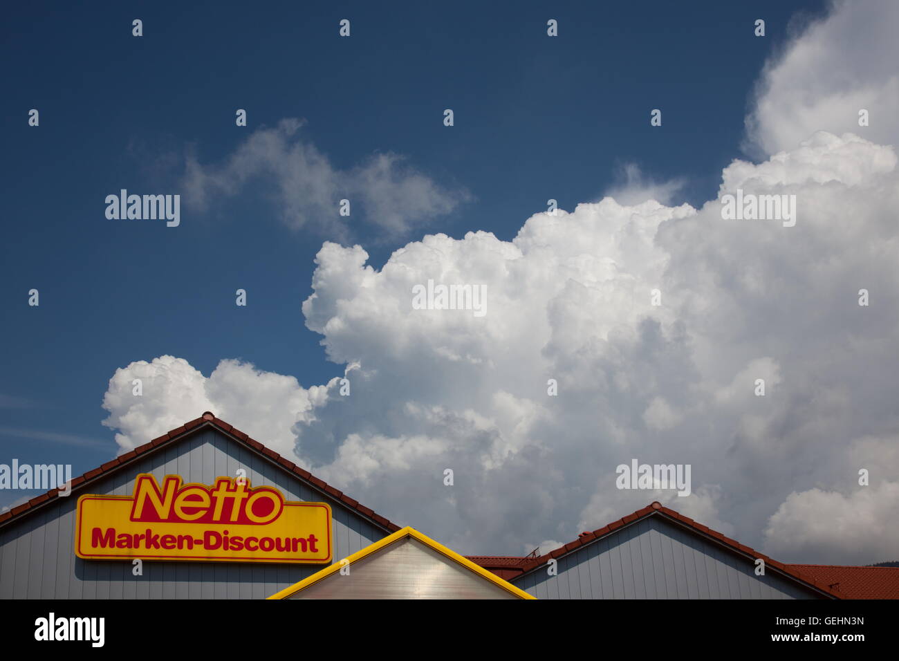 Roof and facade of a Netto Marken-Discount Supermarket and storm clouds ...
