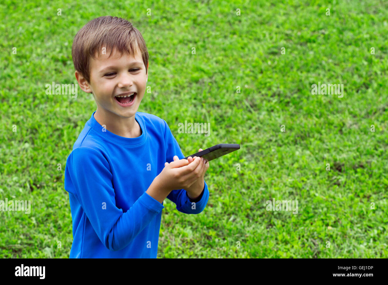 Child with mobile phone outdoor in nature. Childhood, technology ...