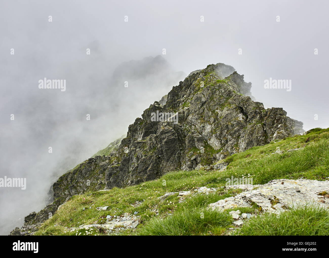 Landscape with rocky mountains seen through the mist Stock Photo - Alamy