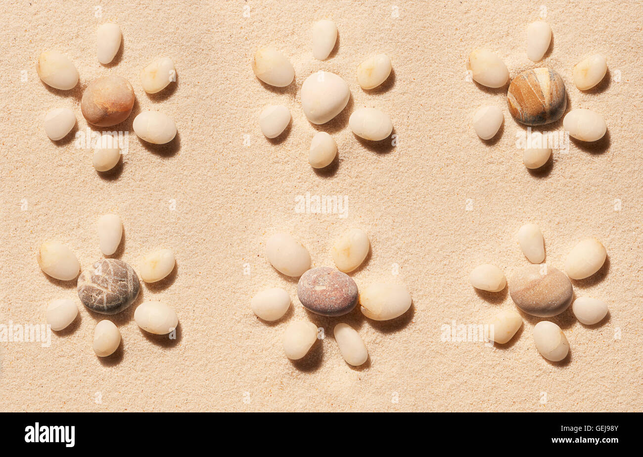 Six flowers made of sea stones on sand. Summer beach background. View ...