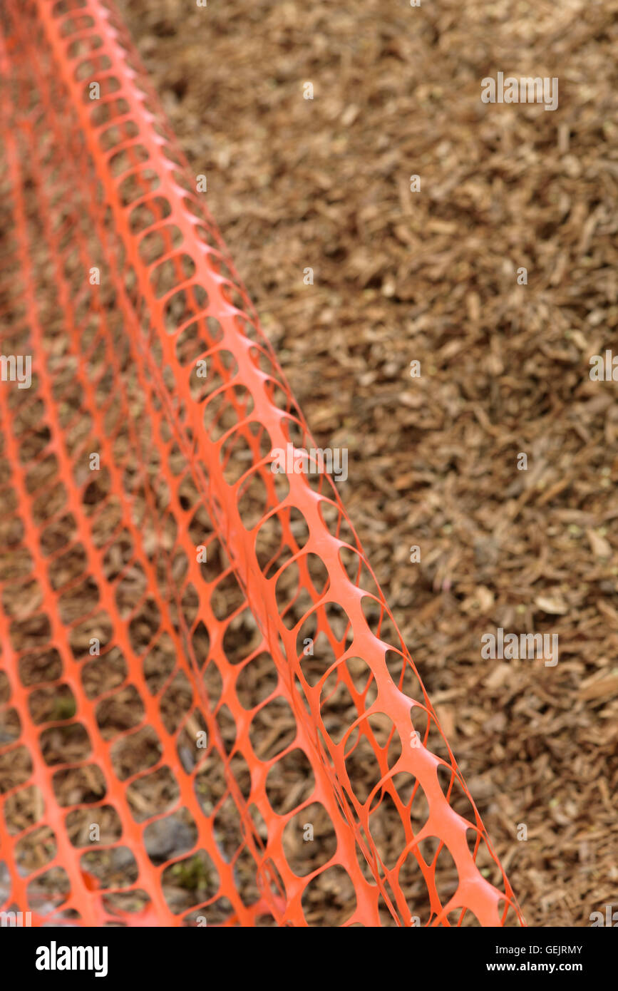 Construction safety fence with wood chips in the background Stock Photo ...