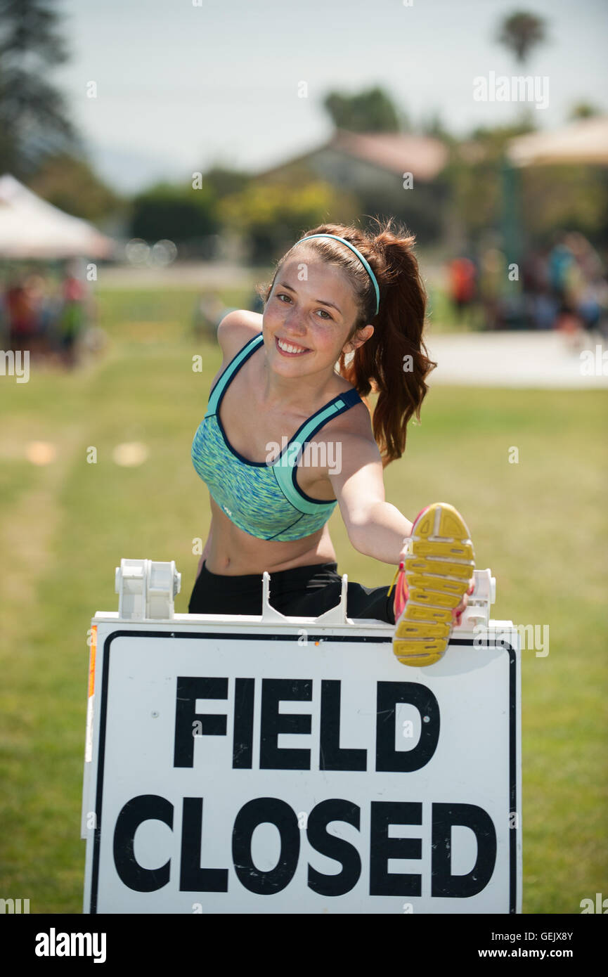 Muscular teen athlete using warning sign to stretch Stock Photo - Alamy