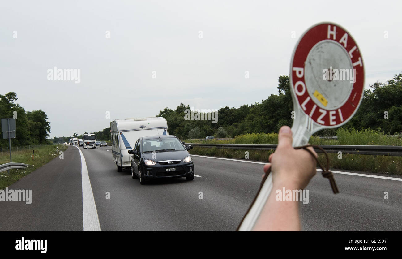 Neuenburg, Germany. 22nd July, 2016. A police officer signals camper ...