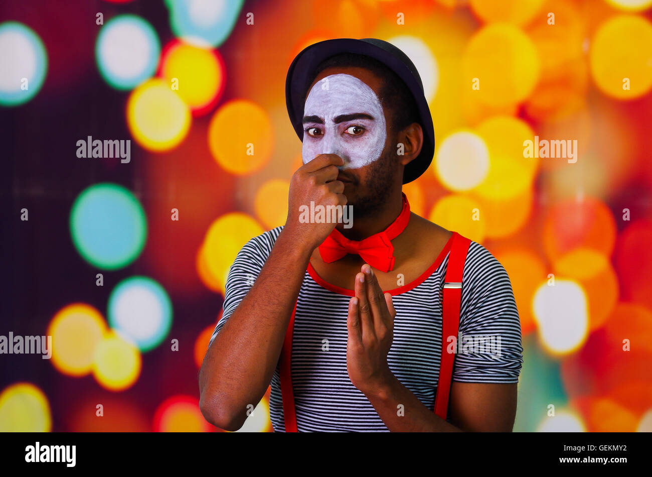 Pantomime man wearing facial paint posing for camera, using hands ...