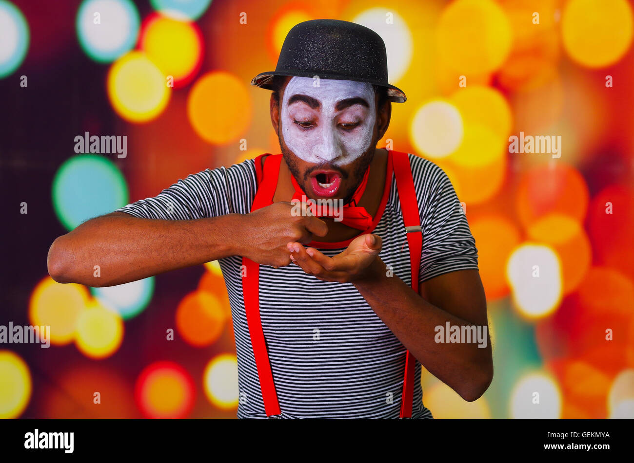 Pantomime man wearing facial paint posing for camera, using hands ...