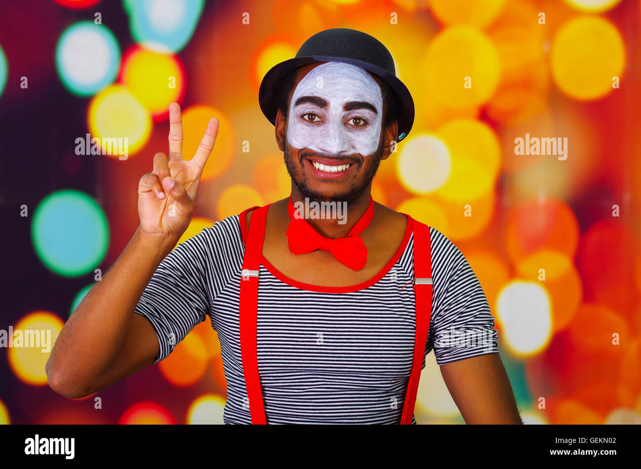 Pantomime man wearing facial paint posing for camera, using hands ...