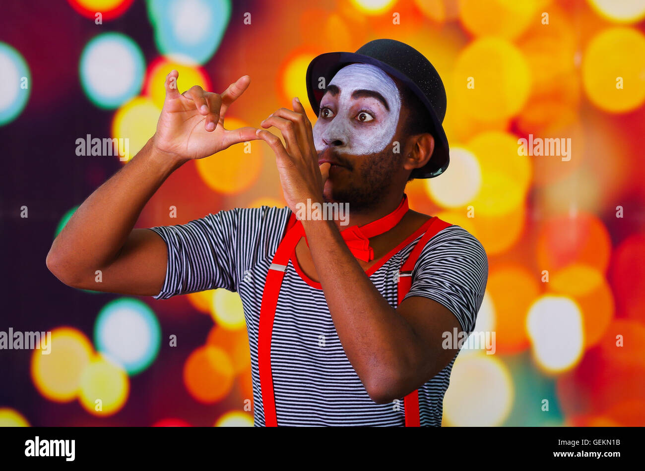 Pantomime man wearing facial paint posing for camera, using hands ...