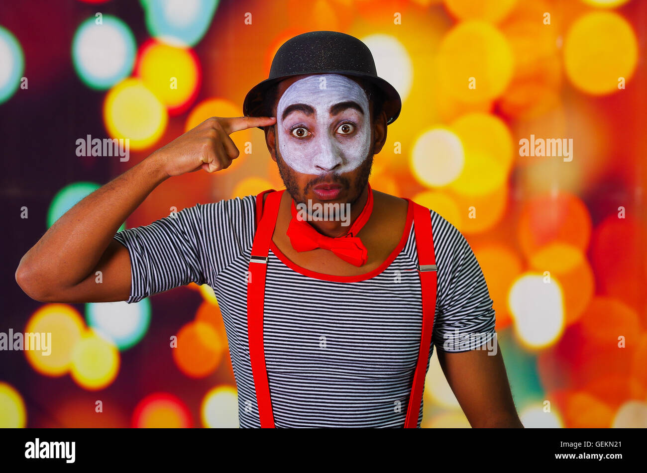 Pantomime man wearing facial paint posing for camera, using hands ...