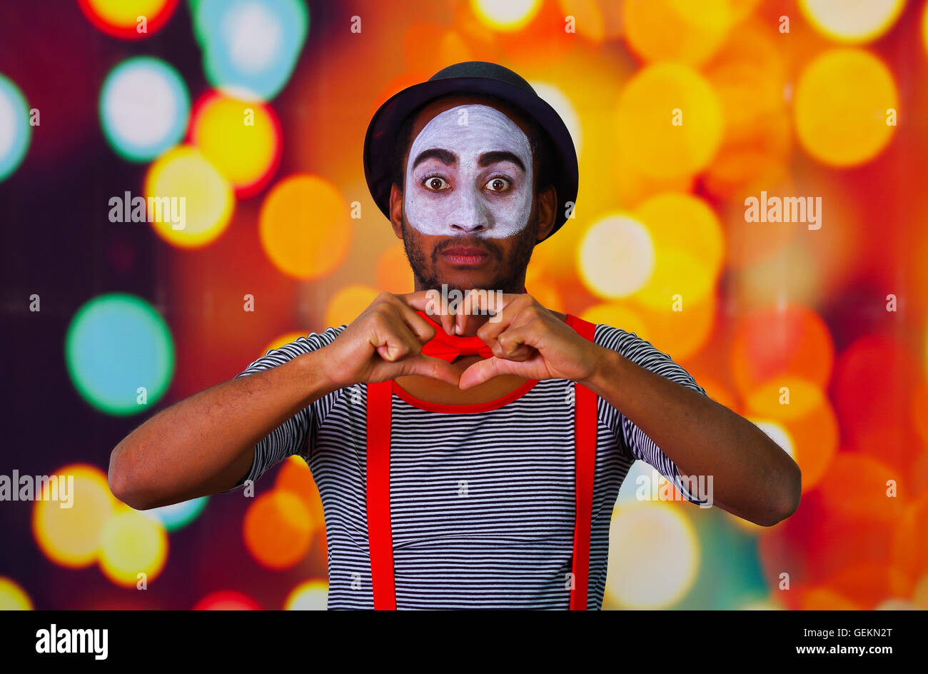 Pantomime man wearing facial paint posing for camera, using hands ...
