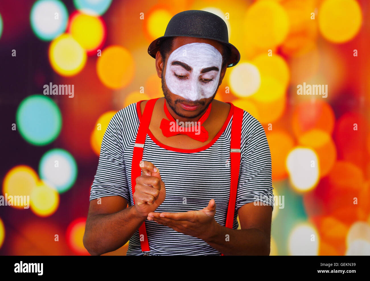 Pantomime man wearing facial paint posing for camera, using hands ...