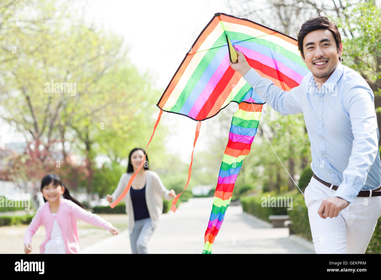 Happy young Chinese family flying a kite Stock Photo - Alamy
