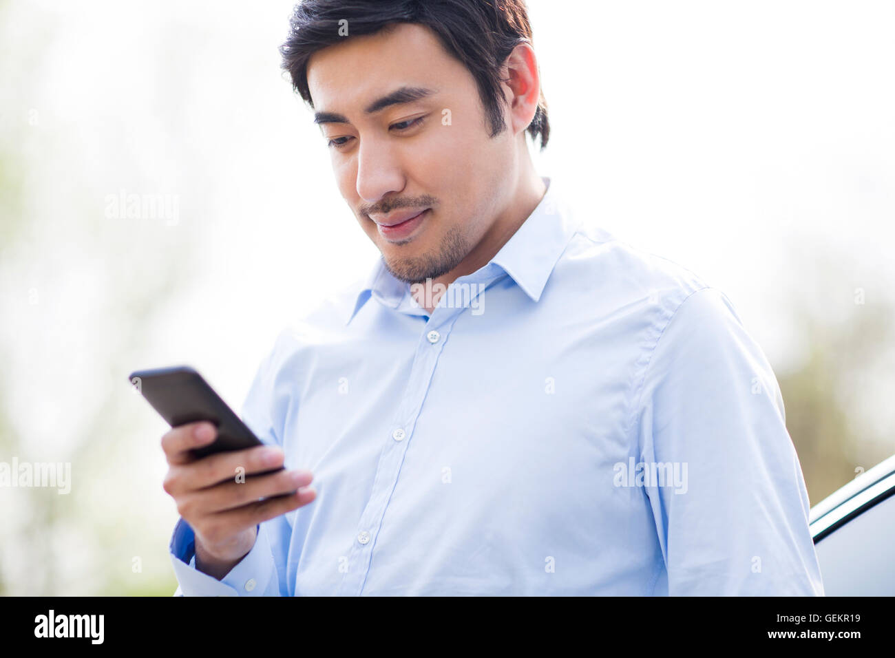 Young Chinese man using a smart phone Stock Photo - Alamy