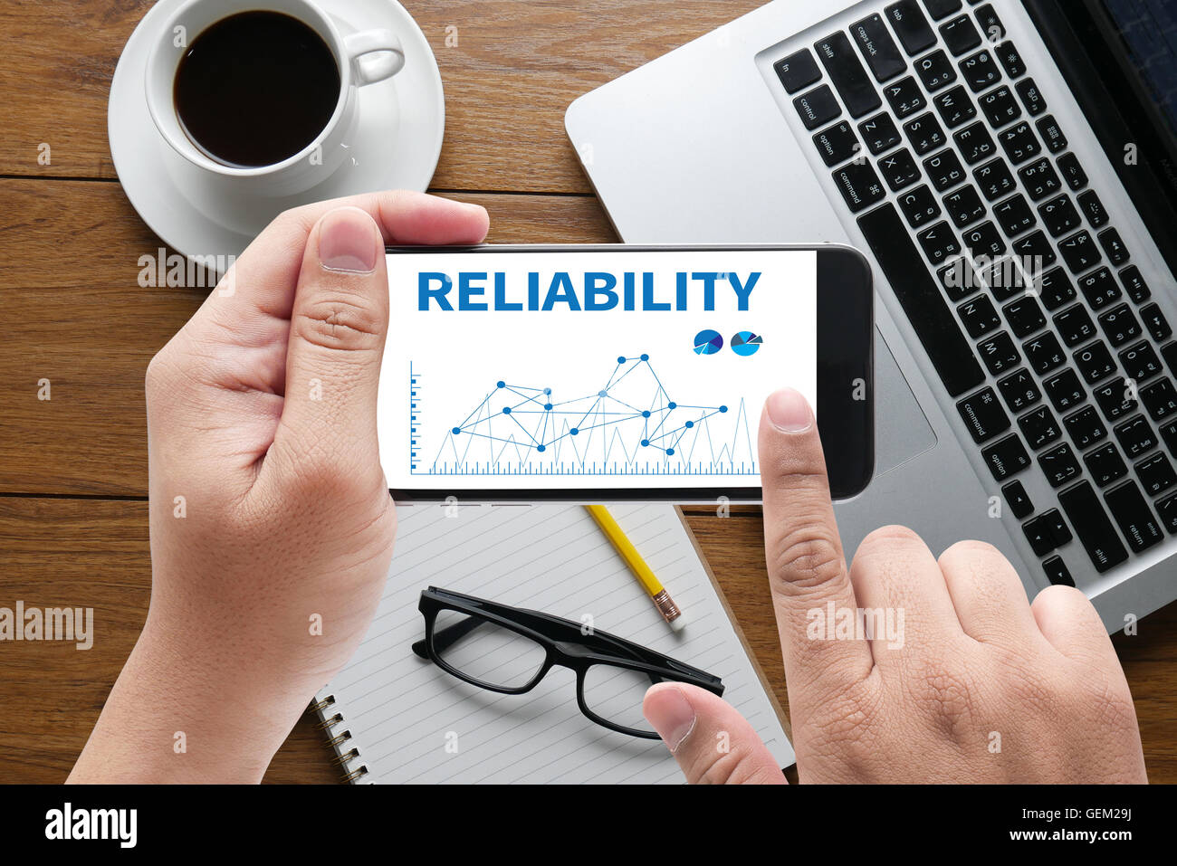 RELIABILITY CONCECT message on hand holding to touch a phone, top view ...