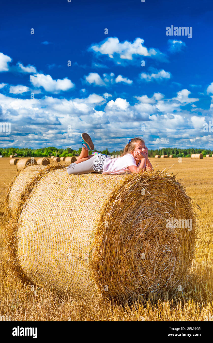 Cute young girl having fun on haystack. Stacks of straw - bales of hay ...