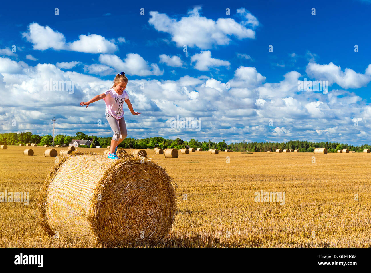 Cute young girl having fun on haystack. Stacks of straw - bales of hay ...