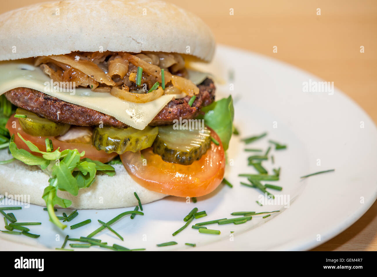 Large beef burger with cheese, pickles, fried onion, tomatoes and ...