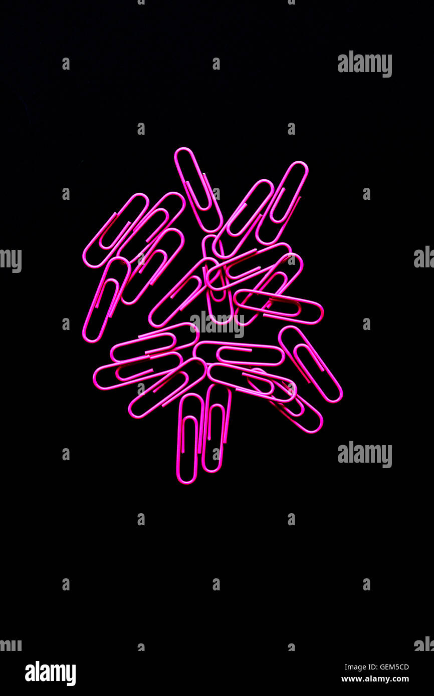 Cluster of bright pink paper clips on a black background Stock Photo ...