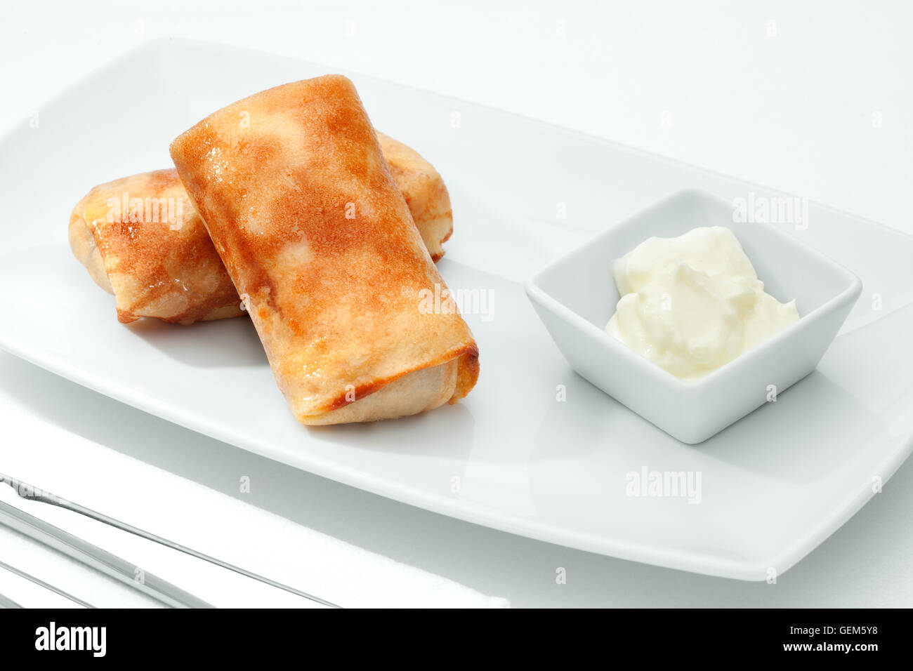 close up view of nice yummy crepes with sour cream on white Stock Photo ...