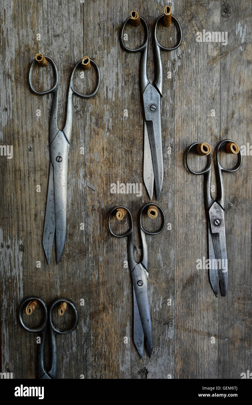 five pairs of old scissors on a wooden background Stock Photo - Alamy
